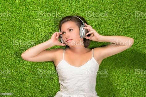 흰색 드레스와 헤드폰을 입은 아름다운 젊은 여성이 잔디 위에 누워 음악을 듣습니다 여름 컨셉 위에서 보기 건강한 생활방식에 대한 스톡 사진 및 기타 이미지 Istock