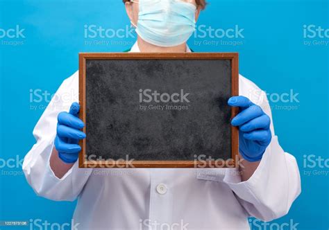 흰색 의료 코트와 파란색 라텍스 장갑을 입은 의사가 빈 나무 검은 색 프레임을 들고 있습니다 건강관리와 의술에 대한 스톡 사진