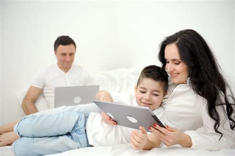 Latest Technology Gadgets Mom And Son Playing On Tablet Father Sitting