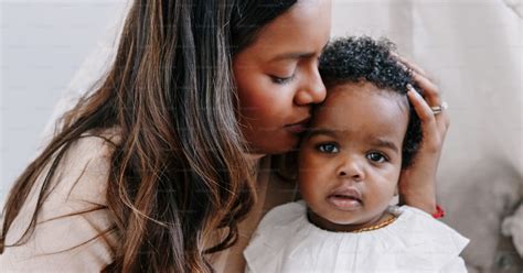 혼혈 흑인 여자 딸에게 키스를 하는 행복한 젊은 인도 어머니 가족 혼혈인 엄마와 아이가 함께 포옹하며 집에서 포옹합니다 인종 다양성 가족 사진 Unsplash의
