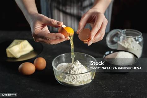 반죽을 준비하는 과정 여자는 계란을 깨고 밀가루 그릇에 추가합니다 여성의 손에 계란과 칼 어두운 배경에 반죽재료 갈색에 대한 스톡 사진 및 기타 이미지 Istock