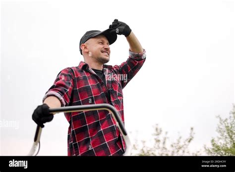 Bottom View Of Tired Man Makes A Short Break While Cutting Grass With A