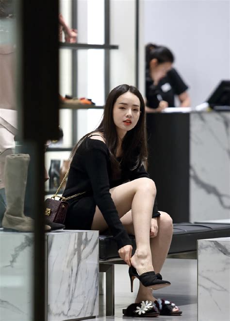 街拍，黑色包臀裙的美女，在商场试高跟鞋