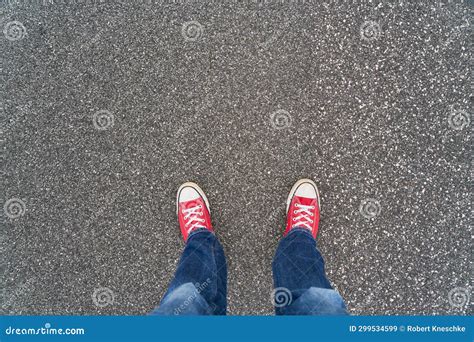 Red Shoes And Jeans Standing On Concrete Pavement As Pov Stock Image