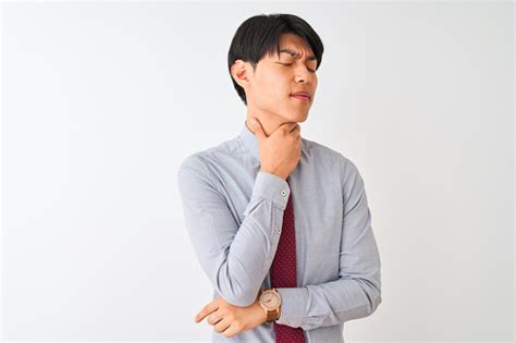 고립 된 흰색 배경 위에 서있는 우아한 넥타이를 입은 중국 사업가 고통스러운 목 독감 Clod 및 감염에 대한 목의 통증 감기와