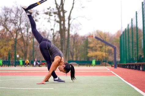 Premium Photo Girl Athlete Training Using Trx On Sportground