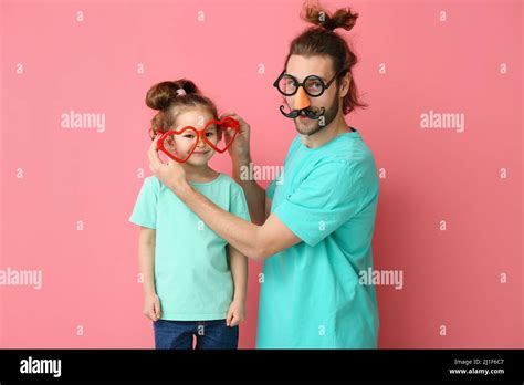 Funny Man And Her Little Daughter In Disguise On Pink Background April