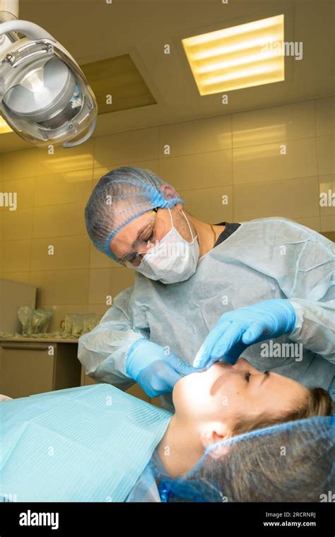Dental Surgeon Examines Patients Mouth Before Removing Wisdom Tooth