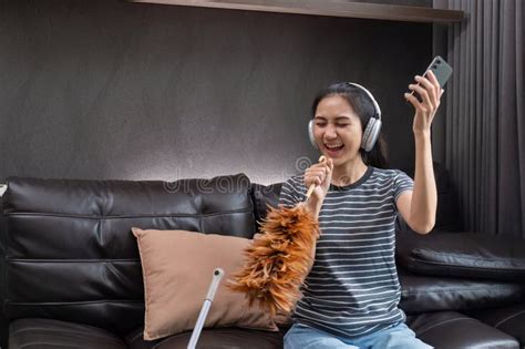 Cheerful And Happy Young Woman Singing And Dancing While Cleaning The