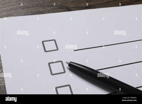 Paper Sheet With Checkboxes And Pen On Wooden Table Closeup Checklist