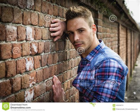 Hombre Joven Que Se Inclina En La Pared De Ladrillo Vieja Foto De Archivo Imagen De Atractivo