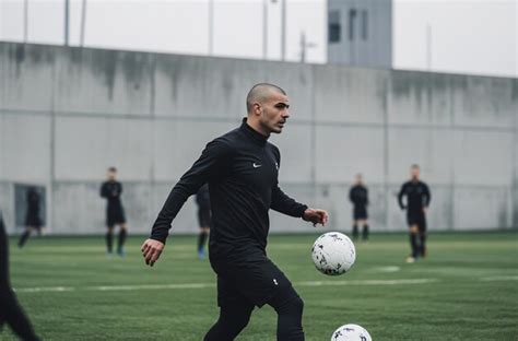 Soccer Player In Black Jersey Juggling The Ball On A Green Field