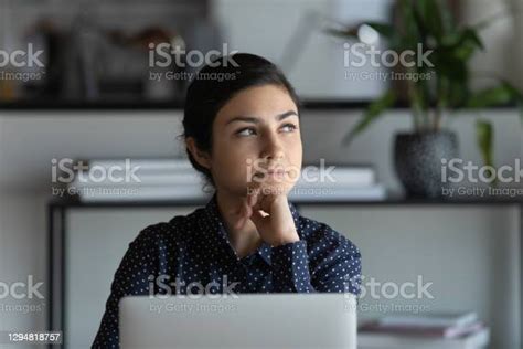 Close Up Thoughtful Indian Businesswoman Touching Chin Using Laptop