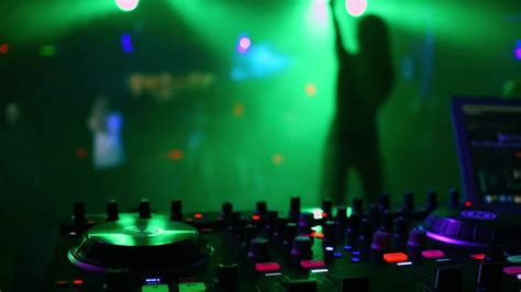Dj Controller Mixer In Nightclub With Blurred Silhouette Of Dancing