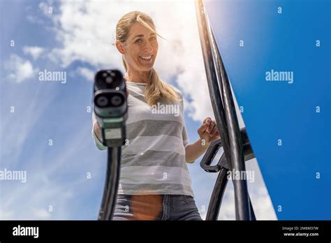 Happy Woman Holding A Dc Ccs2 Ev Charging Plug Connector On
