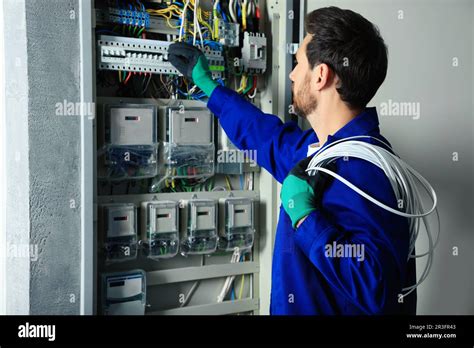Electrician With Wires Switching Off Circuit Breakers In Fuse Box Indoors Stock Photo Alamy