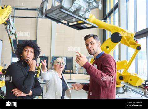 A Diverse Team Engages In Discussion About Robotics And Automation