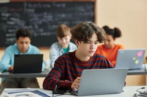Premium Photo Boy Using Laptop Computer In Class During Programming