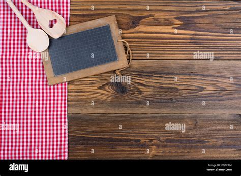 An Old Slate Blackboard And Two Wooden Cooking Spoon On Rustic Wood