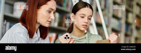 A Redhead Tutor And A Teenage Girl Engrossed In Their Phones In A