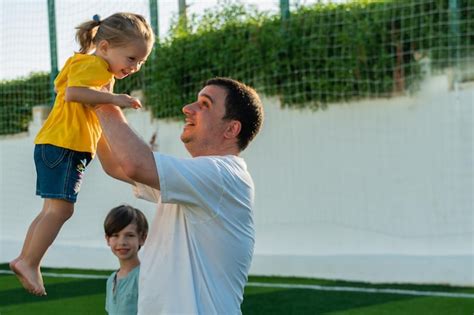 Pai Feliz Segurando A Filha Nas Mãos E Olhando Para Ela Foto Premium