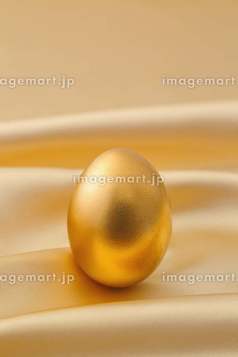 布の上に置かれた金のたまごの写真素材 129295465 イメージマート