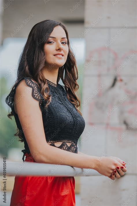 Caucasian Female Posing In The Street In A Red Leather Skirt And An
