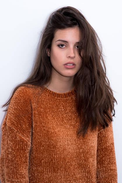 Premium Photo Young Woman Wearing Brown Sweater Standing Against