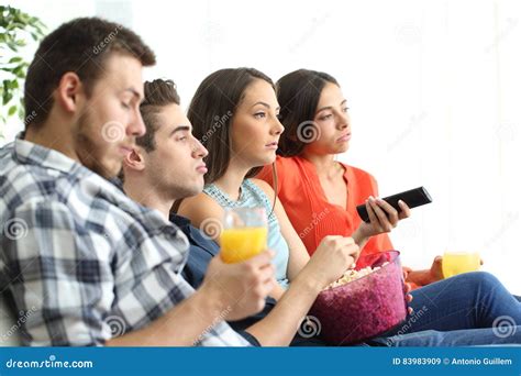 Gebohrte Gruppe Freunde Die Zu Hause Fernsehen Stockbild Bild Von