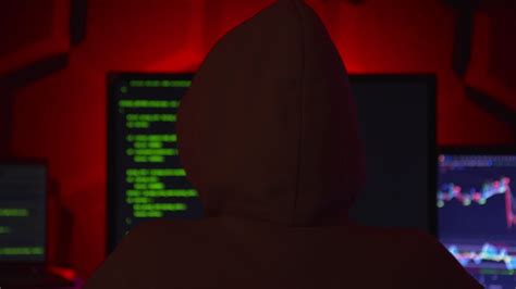 Anonymous Hacker In A Dark Room With Multiple Monitors Writing Code Premium Stock Video Footage
