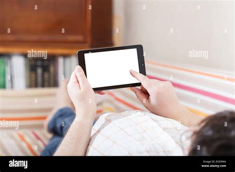 Man Reading With Tablet Pc With Cut Out Screen In Living Room Stock
