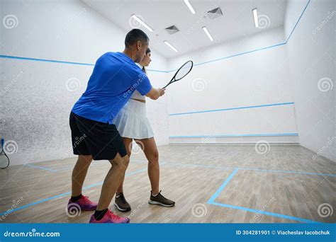 Woman Refines Hitting Precision In Squash Lesson With Man Instructor