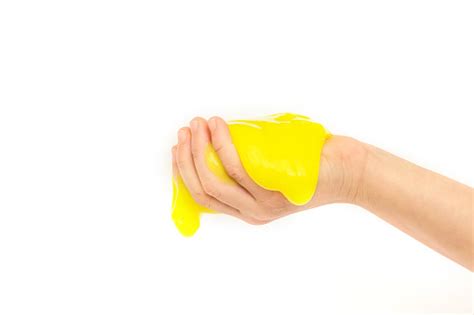 점액이라고 불리는 현대 장난감 아이 재생 투명 노란색 점액 흰색 배경에 점액을 들고 손 선택적 초점 Stem 주제에 대한 스톡