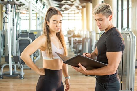 잘 생긴 남성 트레이너와 그의 여성 클라이언트는 체육관에서 그녀의 진행 상황을 논의 피트니스 강사에 대한 스톡 사진 및 기타 이미지 피트니스 강사 고객 스포츠