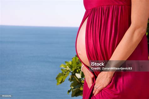 아름 다운 임신한 여자와 숙 녀 포옹 이며 자연 환경에 서 있는 그녀의 임신 배꼽 잡고 아기를 기다리고 있습니다 엄마 손 배