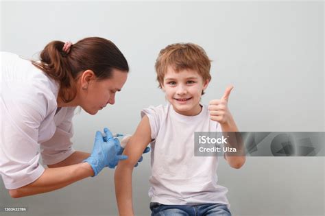 소아과 의사는 병원에서 귀여운 백인 남학생에게 예방 접종을합니다 예방 접종 중 시력 엄지 손가락을 보여주는 어린이 소년 2명에 대한 스톡 사진 및 기타 이미지 Istock