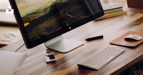 낮 동안 갈색 나무 컴퓨터 책상 위에 놓인 Magic Keyboard 근처의 스페이스 그레이 Imac 사진 Unsplash의