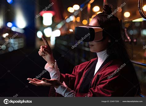 Attractive Asian Girl Using Virtual Reality Headset Pointing Something