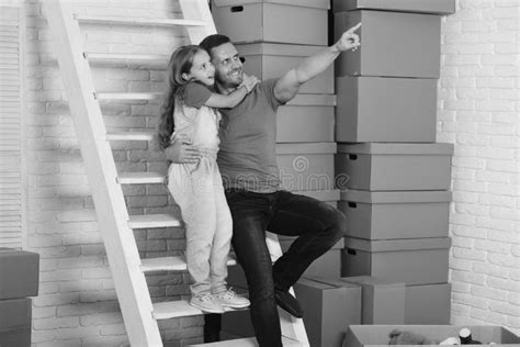 La Hija Y El Padre Se Sientan En La Escalera Blanca Cerca De Las Cajas Imagen De Archivo