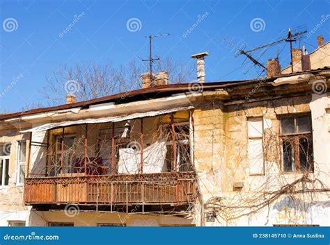 A Part Of Yellow Brown Old Building Facade With Windows And Balcony
