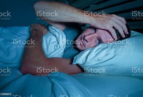 매력적인 남자 넓은 눈으로 잠 못 드는 침대에 누워 밤에 깨어 고통 불면증 수 면 장애 우울 하 고 슬픈 나머지 결핍 스트레스