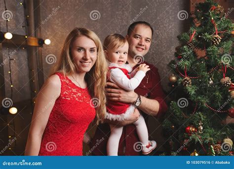Familia Que Adorna El árbol De Navidad En El País Foto de archivo