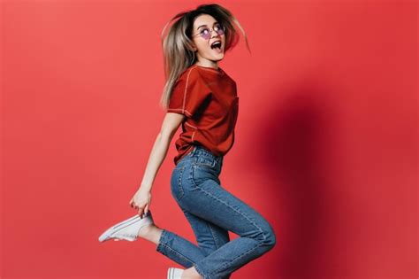 Premium Photo Perky Girl In Red Tshirt And Jeans Jumping On Isolated