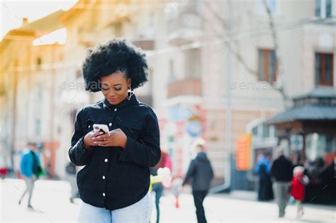 Attractive Happy Dark Skinned Model With Afro Hairstyle And Nose Ring Posing Outdoors Stock