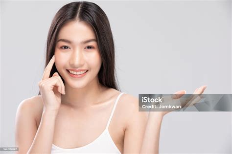 행복 하 고 아름 다운 아시아 젊은 여자는 깨끗하고 맑은 피부로 부드러운 뺨 미소를 만지고 제품 광고에 대 한 손 손바닥 흰색에 고립 된 긍정적 인 느낌으로 광고 미용과