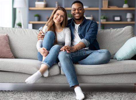Portrait Of Happy Young Interracial Spouses Posing On Couch At Home