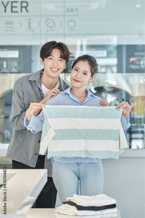 Foto De 셀프 세탁실을 배경으로 커플 또는 신혼부부가 함께 또는 혼자 빨래를 정리하는 모습 아시아 한국 남녀 모델 Do Stock Adobe Stock