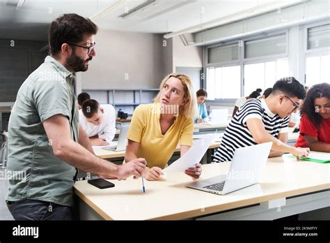 Young Male Teacher Helping Female Student In Class The Tutor Helping