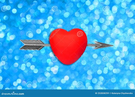Steel Bow Arrow Passed Through A Heart Shape On Blue Stock Image