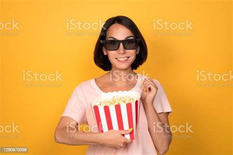 팝콘과 스테레오 3d 안경의 양동이 젊은 갈색 머리 여자의 손에 시네마 컨셉 노란색 배경에서 격리 팝콘에 대한 스톡 사진 및